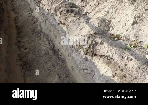 Dug trench in soil for laying utilities and construction Stock Video ...