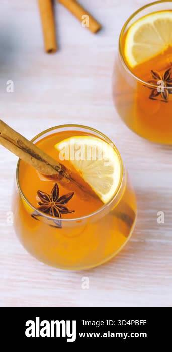 Warm beverage with cinnamon stick, star anise and lemon slice in glass ...