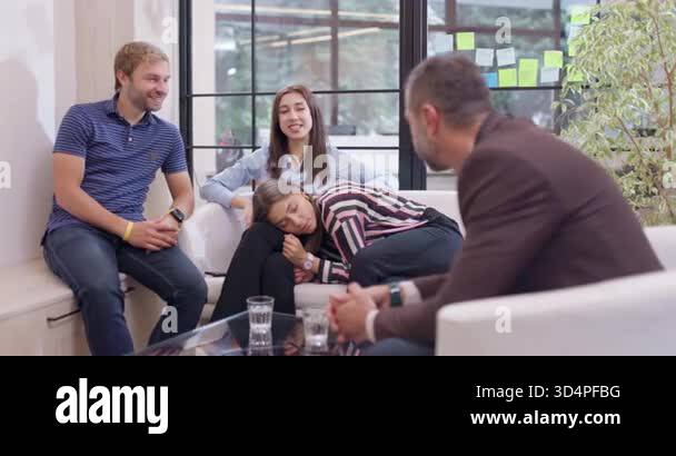 Colleagues comfort a tired, sleeping woman in the office during a ...