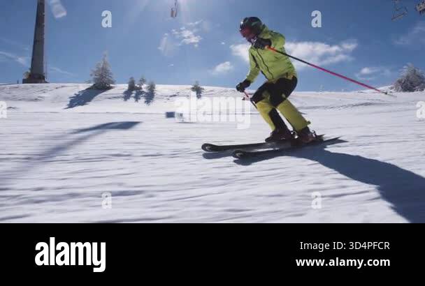 A skilled skier carves through soft, powdery snow on a sloped mountain ...