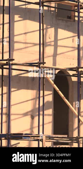 Building with arched window openings surrounded by scaffolding on sunny ...