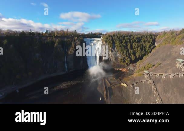 Cinematic aerial of a river flowing into a waterfall surrounded by ...