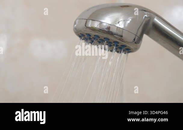 Water flows out of the shower head. Turning off the water from the ...