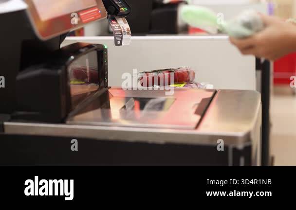 A customer uses a self-checkout machine to pay cashlessly at a ...