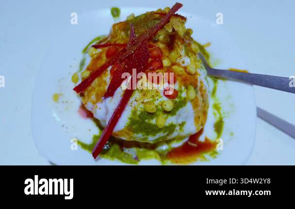 The plate of raj kachori chaat with curd and toppings is shown with a ...