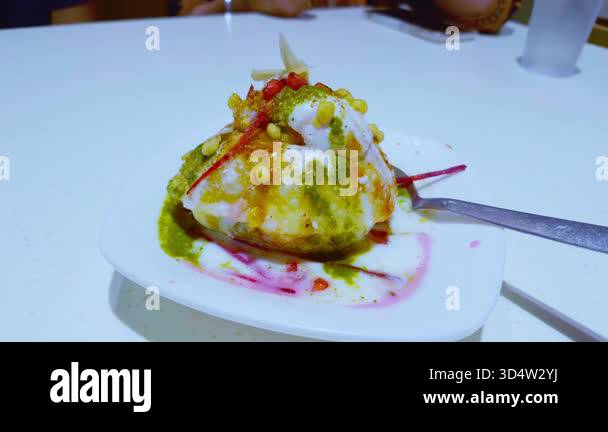 Closeup reveals raj kachori chaat with curd, toppings, and sauces on a ...