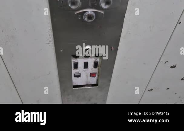 Inside an old lift, buttons and control panel are shown from bottom to ...