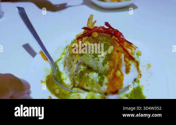 Raj kachori chaat is displayed on a plate topped with curd and various ...
