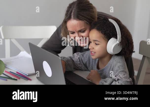 Caucasian mother and African American daughter studying at home, mom ...