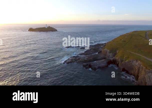 Aerial view of Godrevy point lighthouse at seaside in Cornwall with sun ...