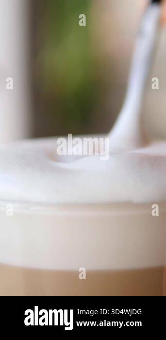 Macro shot of a barista skillfully pouring creamy, frothy steamed milk ...