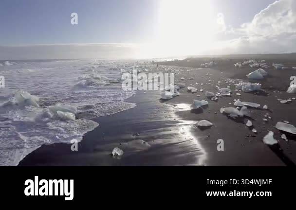 Aerial view of black sand beach with iceberg ice pieces on the shore ...