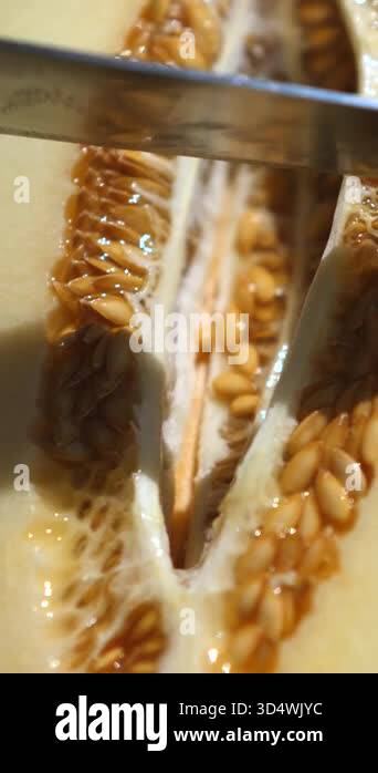 Extreme close up of a sharp knife slicing through a fresh, juicy ...