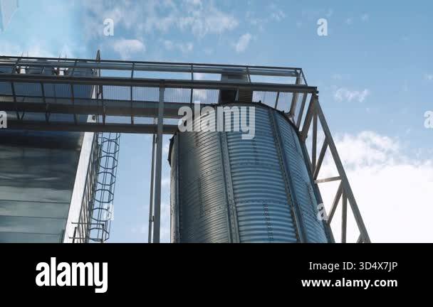 Cylindrical metal silo with safety ladder and elevated catwalk ...