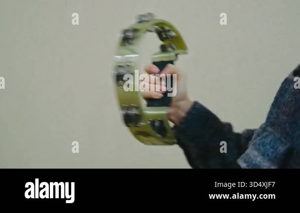 percussionist playing tambourine, closeup of hand twirling percussion ...