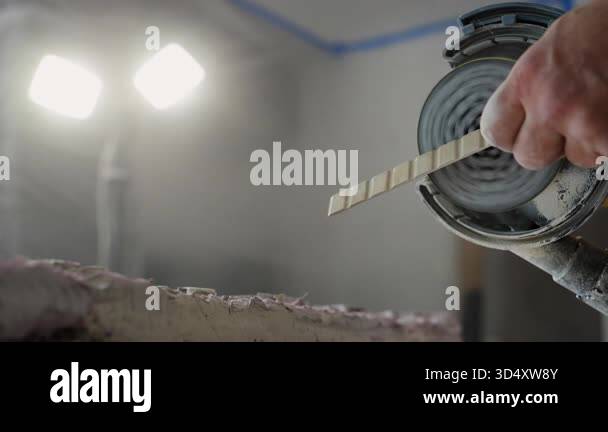 Worker smoothing ceramic tile angle with tile cutter on workbench ...
