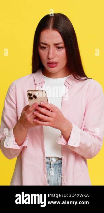 Young woman irritated looking at smartphone screen with annoyed facial ...