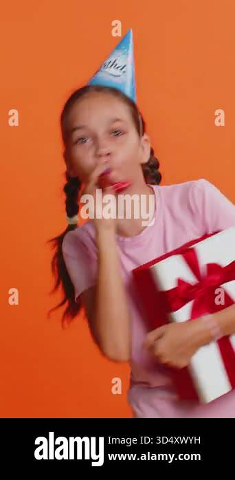 Young teen child girl kid holding gift box wearing birthday cone hat ...