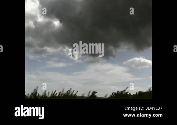 Dramatic storm clouds forming above treetops in nostalgic VHS 90s ...