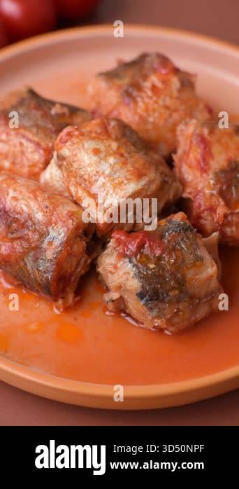 Hake fish cooked in pieces in tomato sauce, stew with peppers and ...