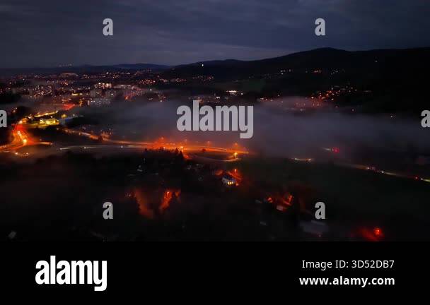 misty town with glowing roads, predawn mist envelops illuminated ...