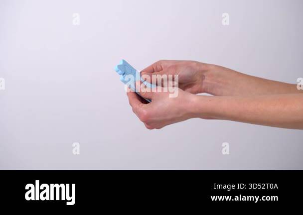 Female hands separating a blue foam toe separator on a white background ...