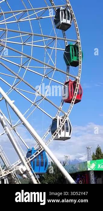 A section of a large Ferris wheel with an intricate white metal grille ...