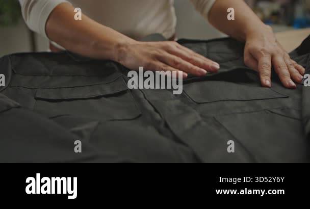 Close up of a womans hands opening the Velcro fasteners on a black ...