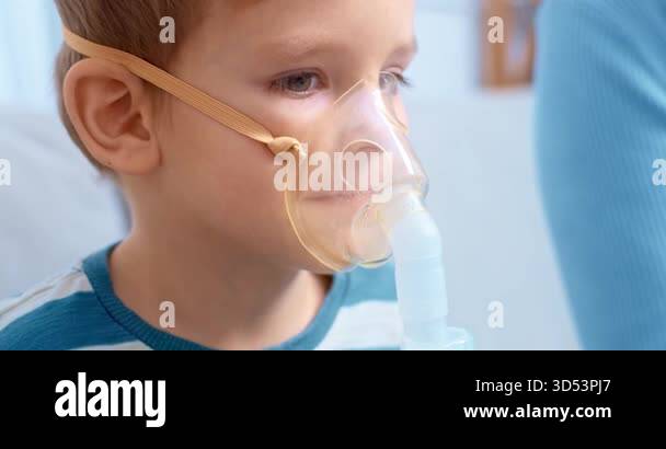A young child wearing a nebulizer mask receives a breathing treatment ...
