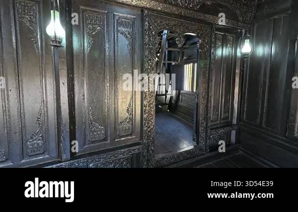 Detailed hand-carved floral motifs adorn the wooden wall of a ...