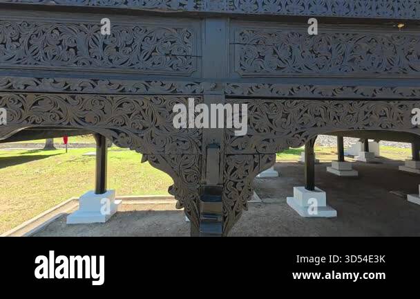 Detailed hand-carved floral motifs adorn the wooden wall of a ...