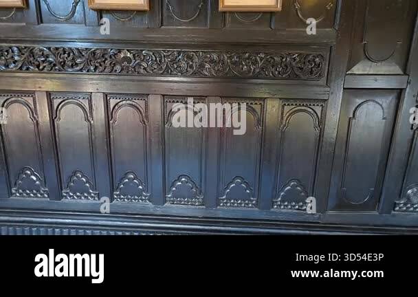 Detailed hand-carved floral motifs adorn the wooden wall of a ...