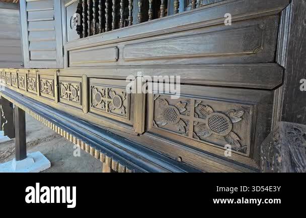 Detailed hand-carved floral motifs adorn the wooden wall of a ...