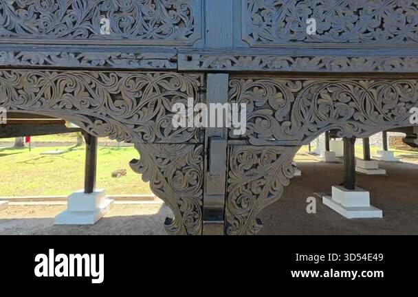 Detailed hand-carved floral motifs adorn the wooden wall of a ...