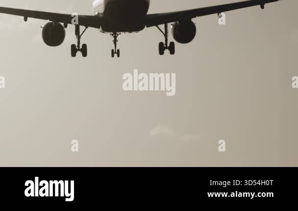 airplane flying overhead to land at airport in super slow motion at ...