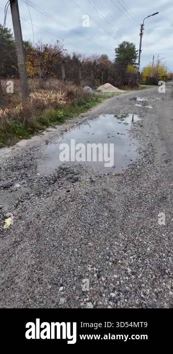 Puddles on the road, slow motion. Autumn raindrops fall into a large ...