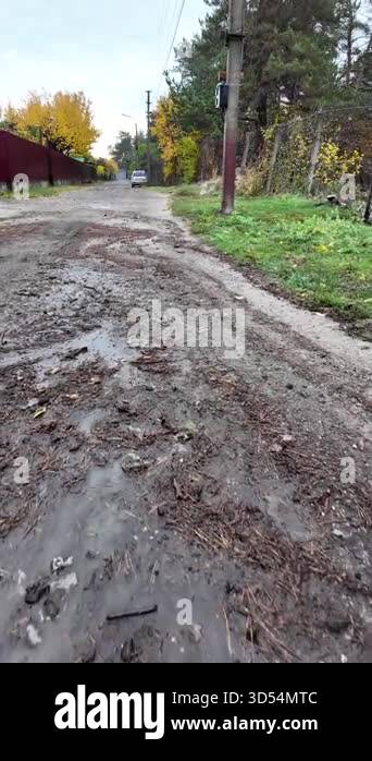 Puddles on the road, slow motion. Autumn raindrops fall into a large ...