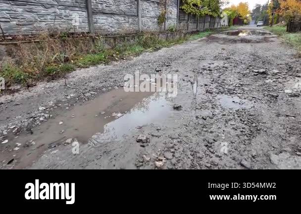 Puddles on the road, slow motion. Autumn raindrops fall into a large ...