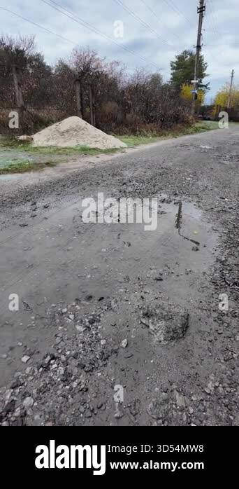 Puddles on the road, slow motion. Autumn raindrops fall into a large ...