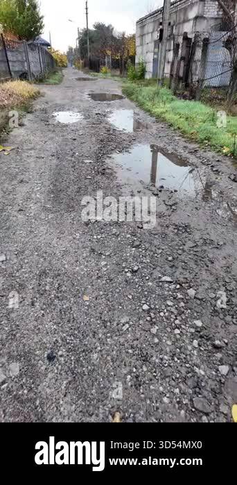 Puddles on the road, slow motion. Autumn raindrops fall into a large ...