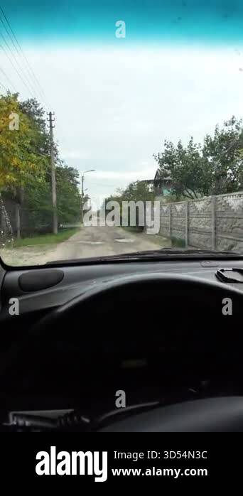 Drivers perspective from inside a car on a sunny day, hand on steering ...