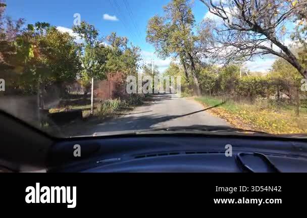 Drivers perspective from inside a car on a sunny day, hand on steering ...