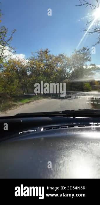 Drivers perspective from inside a car on a sunny day, hand on steering ...