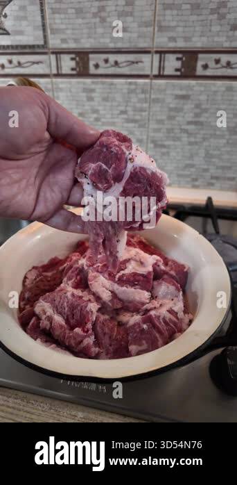 A chef holds a steak in his hand. Meat chop. Home cooking. Cooking meat ...