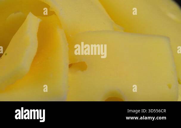 Slices of Emmental cheese on a black rotating background. Slices of ...