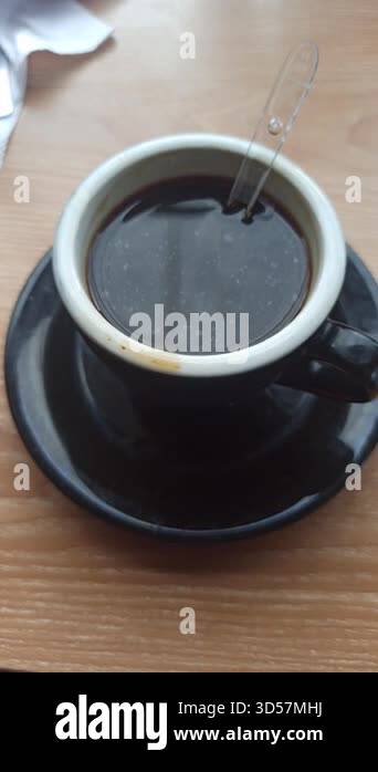 A steaming cup of black Americano coffee, rich and bold, served in a ...