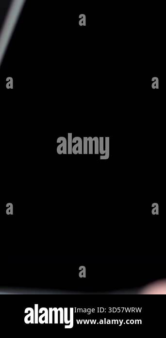 Close-up of a person opening a laptop with a red screen displaying a ...