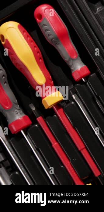 Brightly colored screwdrivers are neatly arranged in a black tool ...