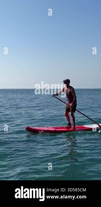 Sportsman paddling on a stand up paddle board, demonstrating the ...