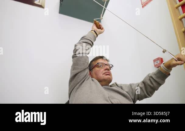 Determined man in a wheelchair performing physiotherapy exercises for ...